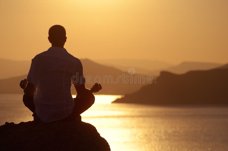 Guy meditating at sunset stock photo. Image of relax - 26397856