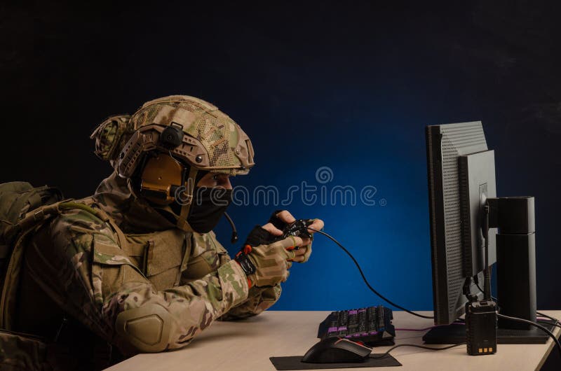 A Guy in a Military Uniform is Sitting Playing Computer Games on a ...