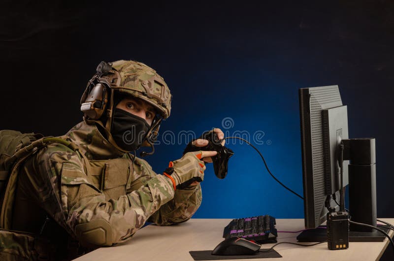A Guy in a Military Uniform is Sitting Playing Computer Games on a ...