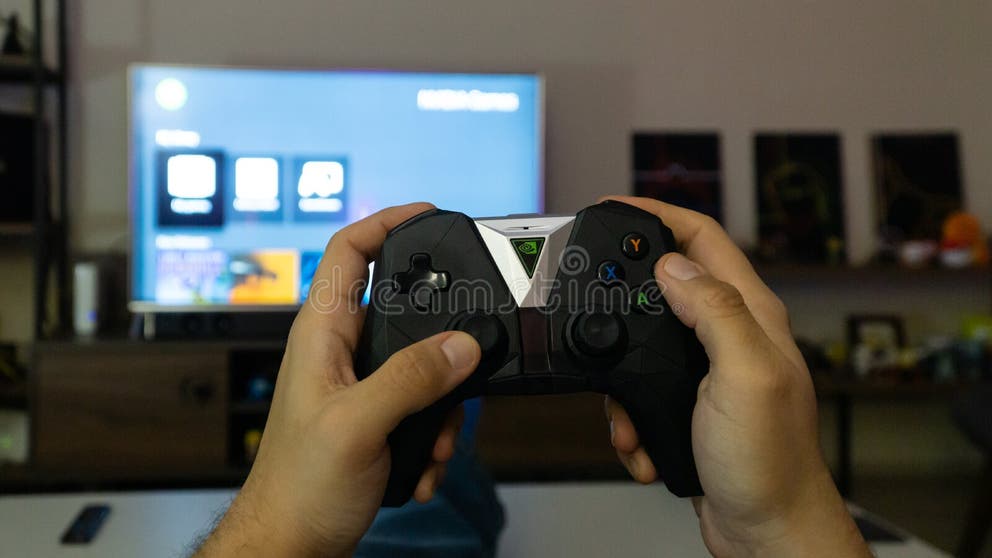 Guy with Nvidia Shield Controller with a Television in the Background ...