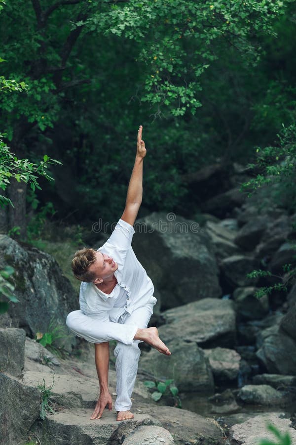 The Guy Performs the Balance Asana on One Leg. Meditation in Nature ...