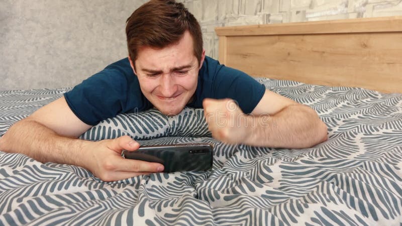 Guy Plays the Phone and Gets Angry Lying on the Bed Stock Video - Video ...