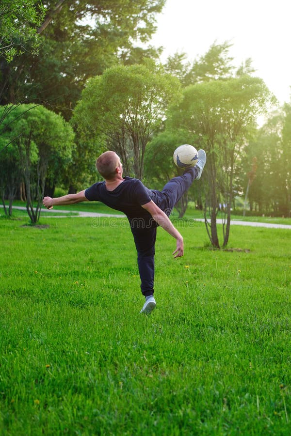 Guy Plays with a Soccer Ball on the Park Lawn, Kick in the Fall through ...
