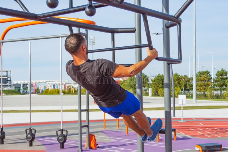 The Guy Pulls Up on the Horizontal Bar Under an Incline in the City ...