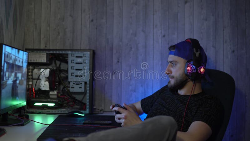 Guy Relaxed in Headphones Plays Computer Games with a Joystick Stock ...