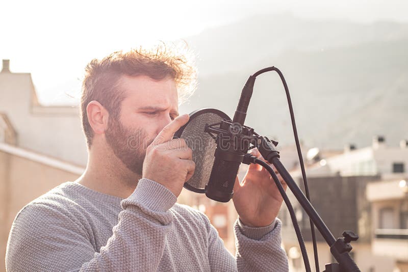 Guy singing on a rooftop stock photo. Image of balcony - 115366636