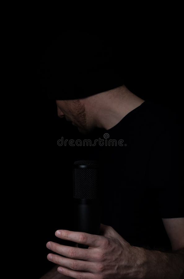 The Guy Sings into a Microphone on a Dark Background Stock Image ...
