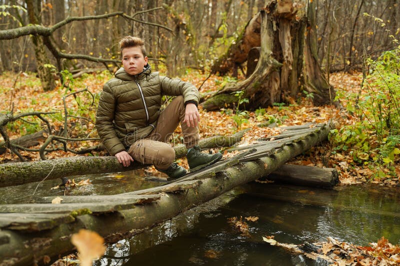 A Guy Sits on the Bridge Over the Stream Stock Photo - Image of green ...