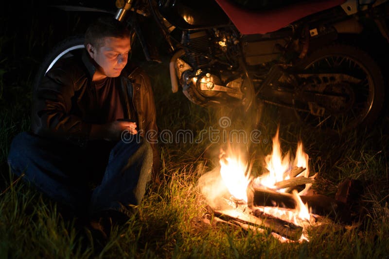 The Guy Sits with Cup of Tea by the Fire and Motorcycle at Night Stock ...