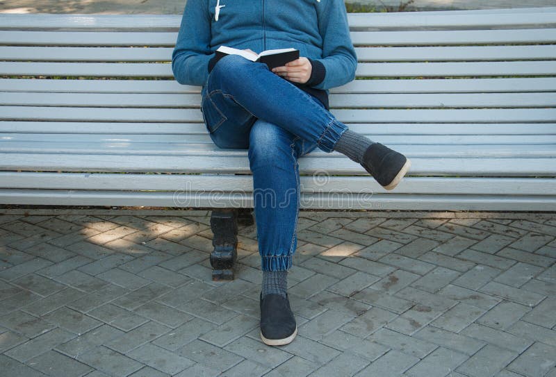 Guy Sitting on a Bench Legs Crossed Stock Photo - Image of bench ...