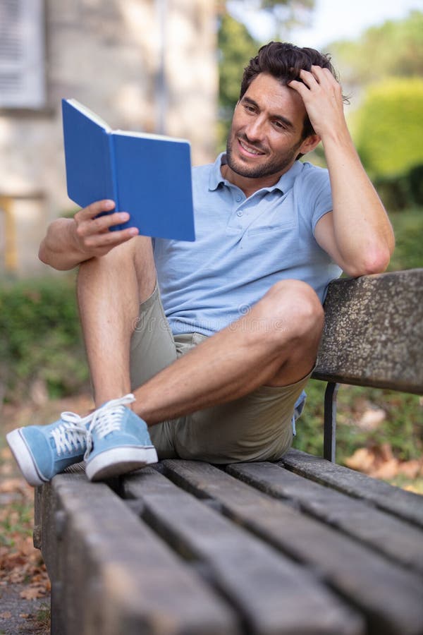 Guy Sitting on Bench in Park Reading Book Stock Image - Image of shirt ...