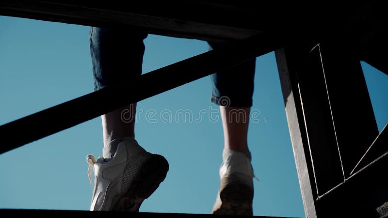 The Guy is Sitting with His Legs Dangling on the Edge of the Bridge at ...