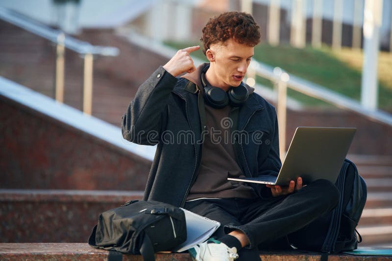 Guy is Sitting and Using Laptop. Young Student is Outside the ...