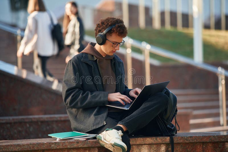 Guy is Sitting and Using Laptop. Young Student is Outside the ...