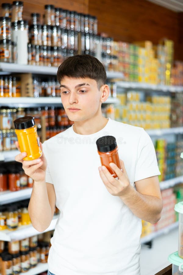 Guy is Standing in Spice Section of Supermarket and Choosing Jar of ...