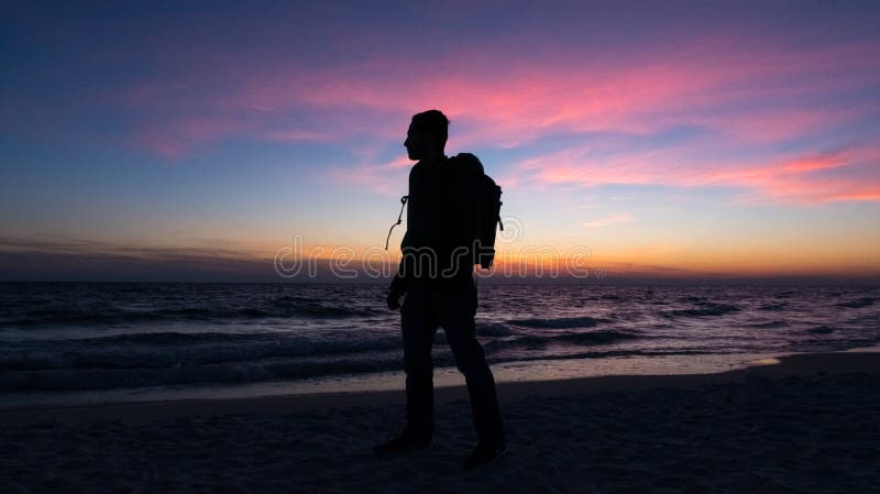 Guy Stands in Front of Dramatic Sunset Over the Ocean Stock Image ...