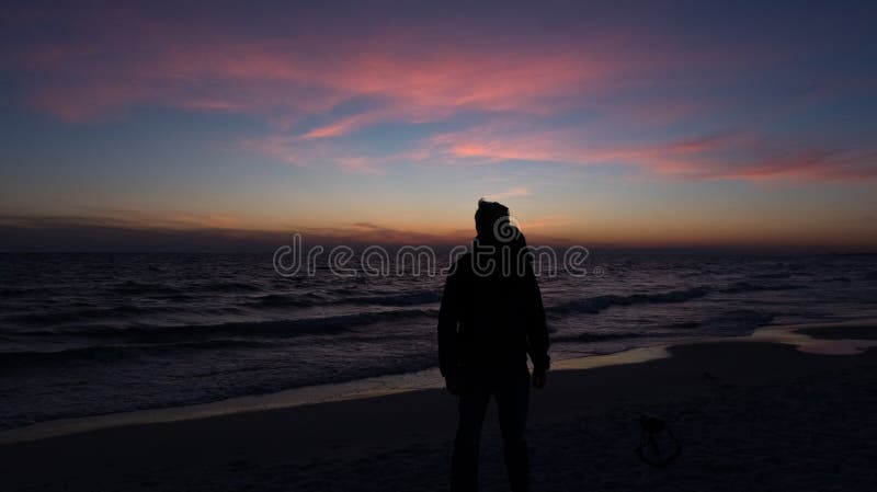Guy Stands in Front of Dramatic Sunset Over the Ocean Stock Image ...