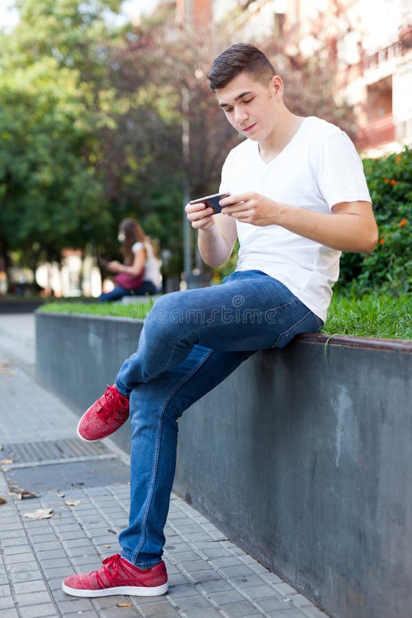 Guy Texting on His Smartphone in Park Stock Photo - Image of leisure ...