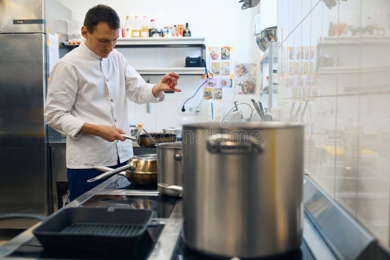 Guy in a Uniform Prepares Food in a Restaurant Kitchen Stock Image ...