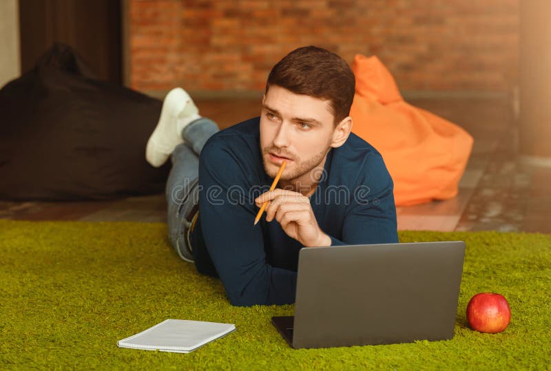 Guy Using Laptop Thinking Lying on Floor in Coworking Workspace Stock ...