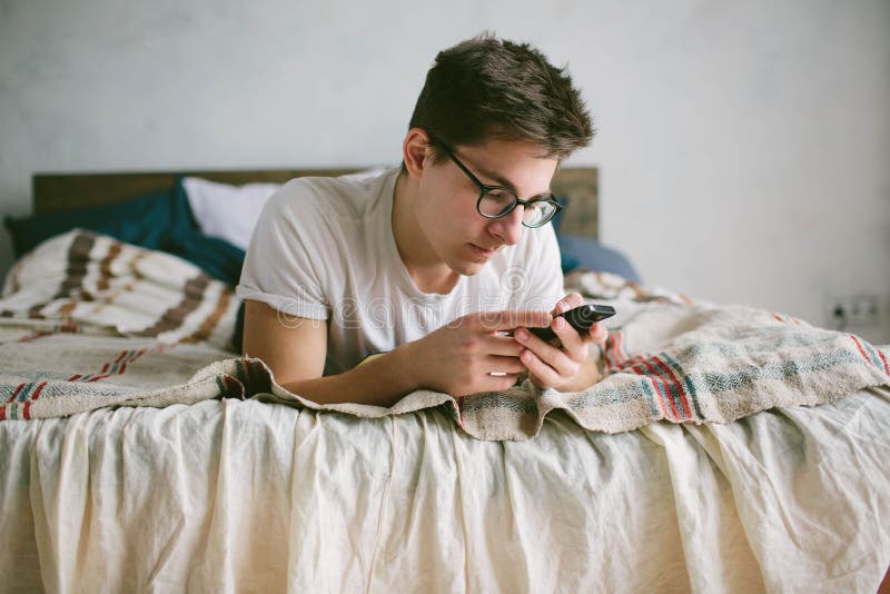 Guy Using Remote Control while Sitting on the Bed in Home. Happy ...