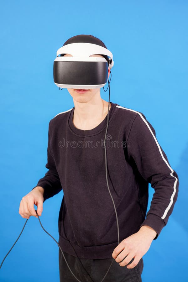 A Guy in a VR Helmet is Immersed in Virtual Reality while Playing a ...