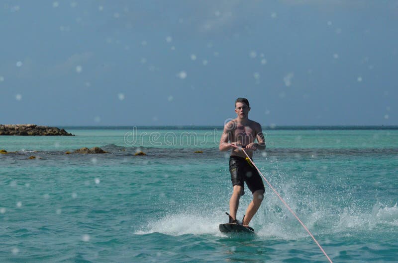Guy Wakeboarding Muscular Con El Espray En Aruba Foto de archivo ...