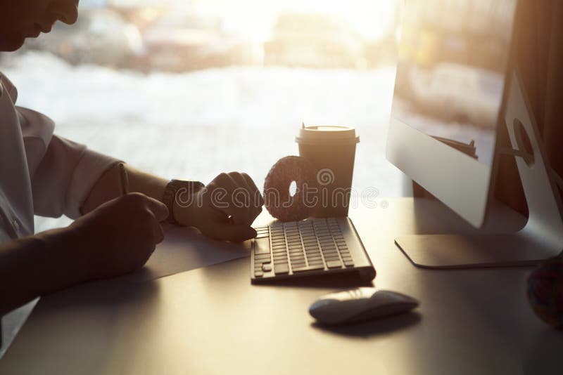 The Guy Working at the Computer and Drinking Coffee with a Donut Stock ...
