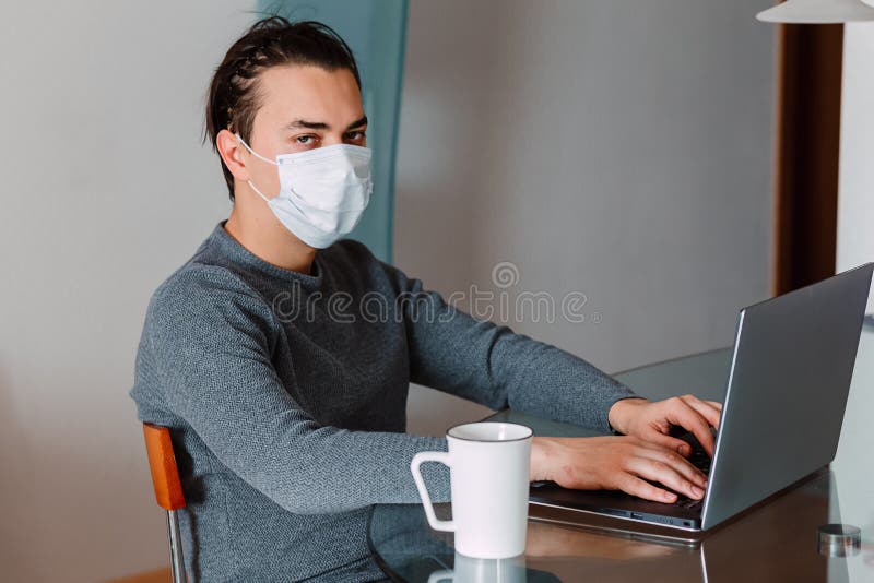 Guy Working at Home with Protective Mask on Laptop Stock Photo - Image ...