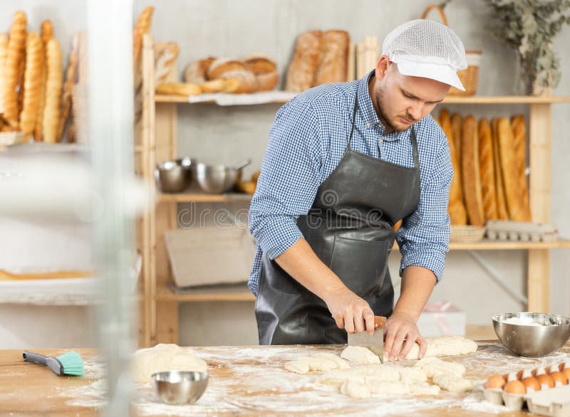 Guy Works in Bakery As Baker, Cuts Dough into Portions, Forms Pieces of ...