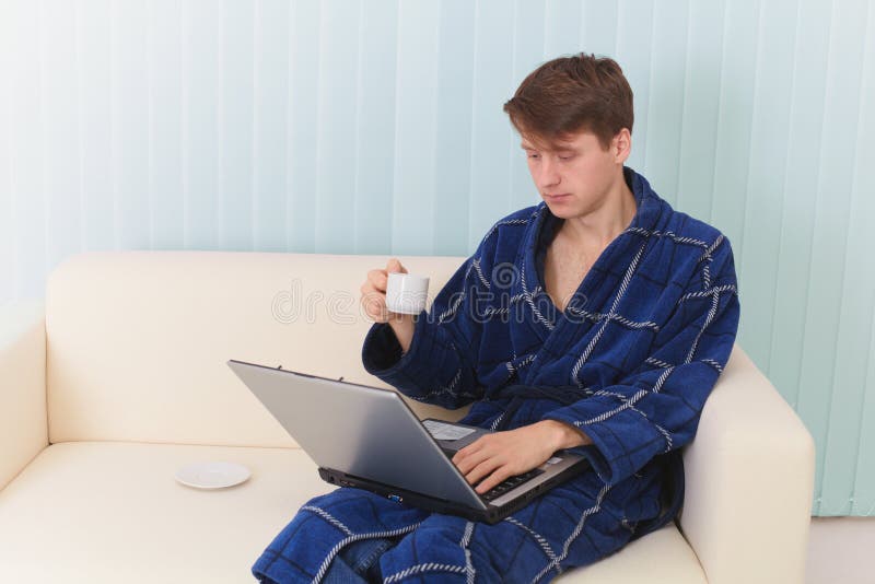 Guy Works in Internet on Sofa and Drinks Coffee Stock Photo - Image of ...
