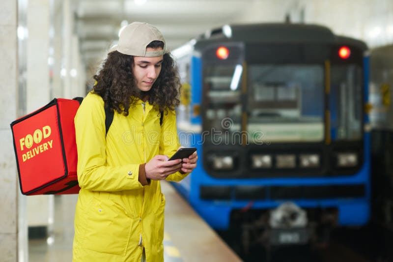 Guy in Yellow Uniform with Big Red Backpack on His Back Using ...