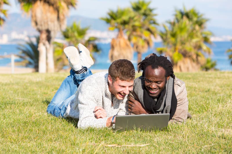 Guys Sharing Computer in Grass Stock Image - Image of computer ...