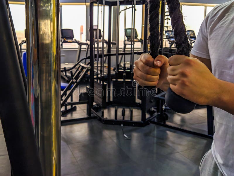 Gym Equipment in a Modern Gym with Young Man`s Hands Pulling the Rope ...