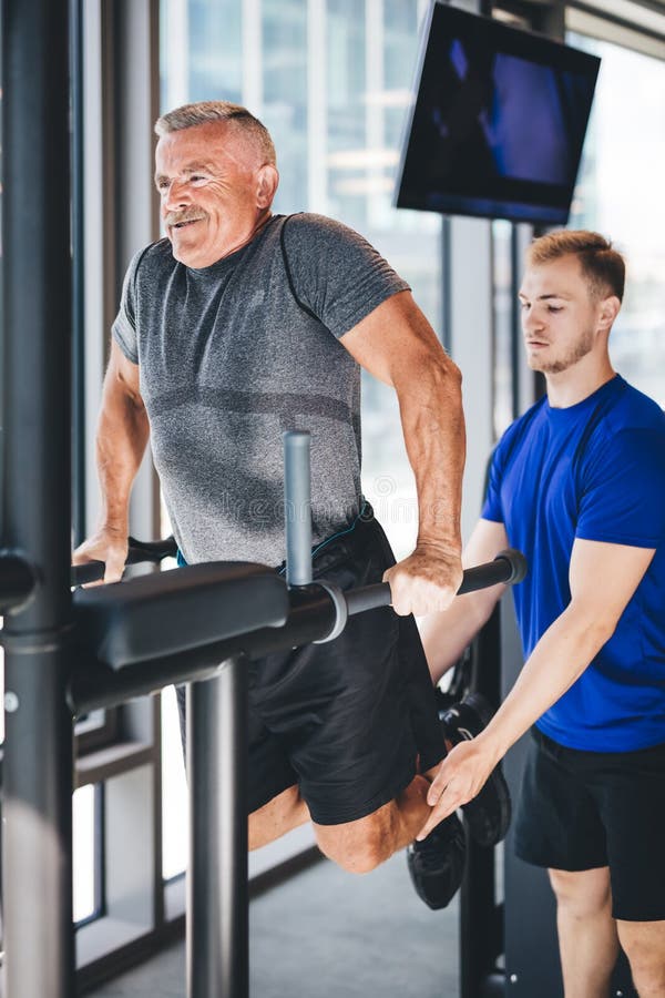 Gym Instructor Helping Senior Man at the Gym. Stock Image - Image of ...