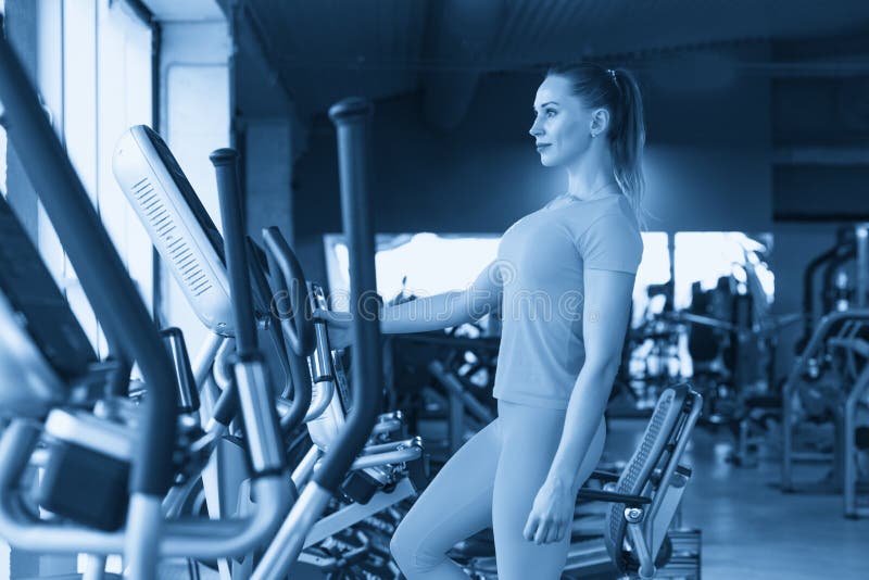 Woman Working Out on Elliptical Machine in Gym Stock Photo - Image of ...