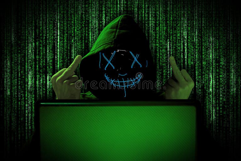 Hacker with Blue Glowing Mask Behind Notebook Laptop in Front of Green Source Binary Code ...