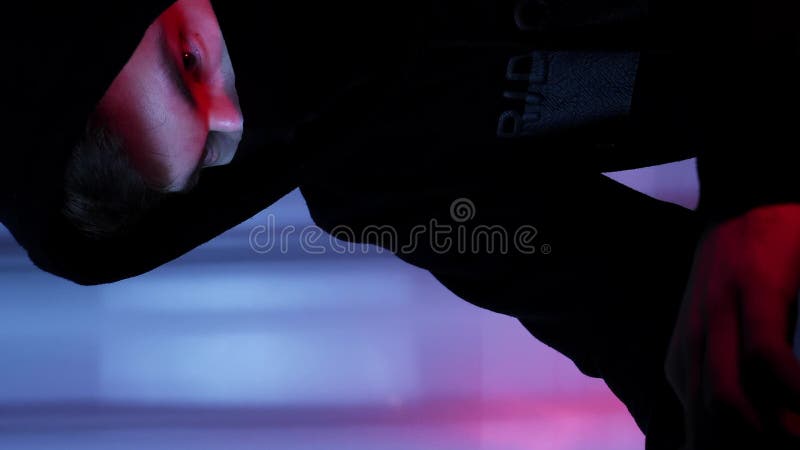 Hacker Face in Black Mask and Hood Sitting in Dark Room. Vertical Video ...