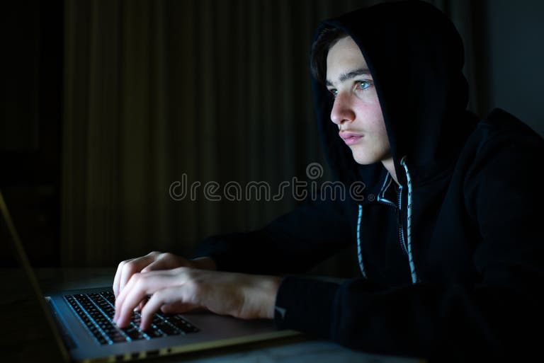 Hacker is Hacking into the Computer Network. Young Boy in a Dark Room ...