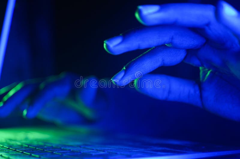 Hacker Hands Typing on a Laptop Illuminated by Blue and Green Light ...