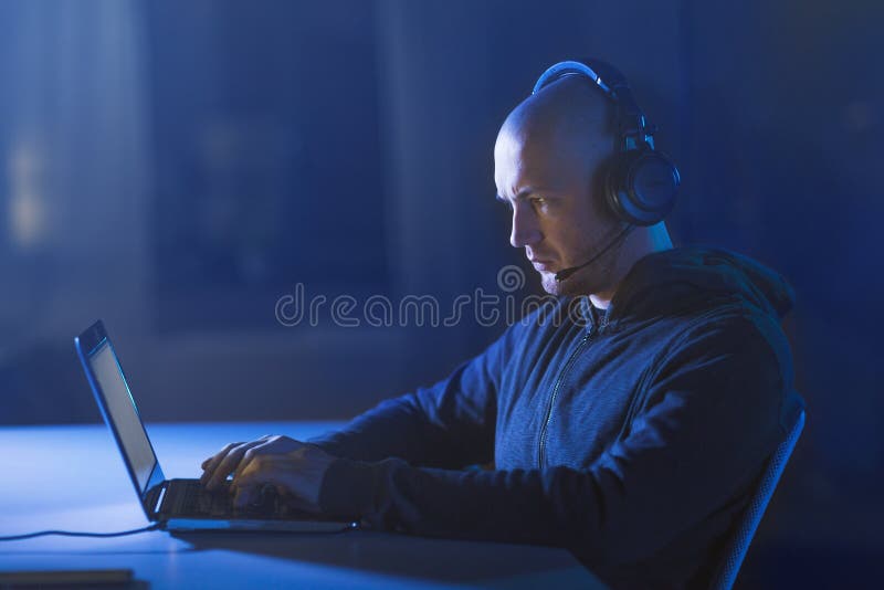 Hacker in Headset Typing on Laptop in Dark Room Stock Image - Image of ...