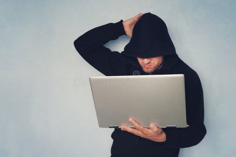 Hacker with His Computer Thinking on Blue Background. Hacker in a Black ...