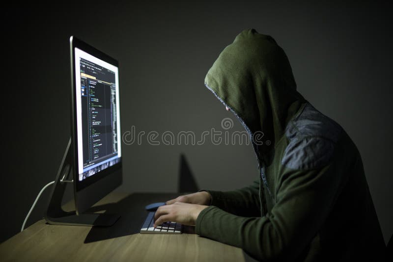 A Hacker in a Hood on a Dark Background Hacking Computer Networks in ...