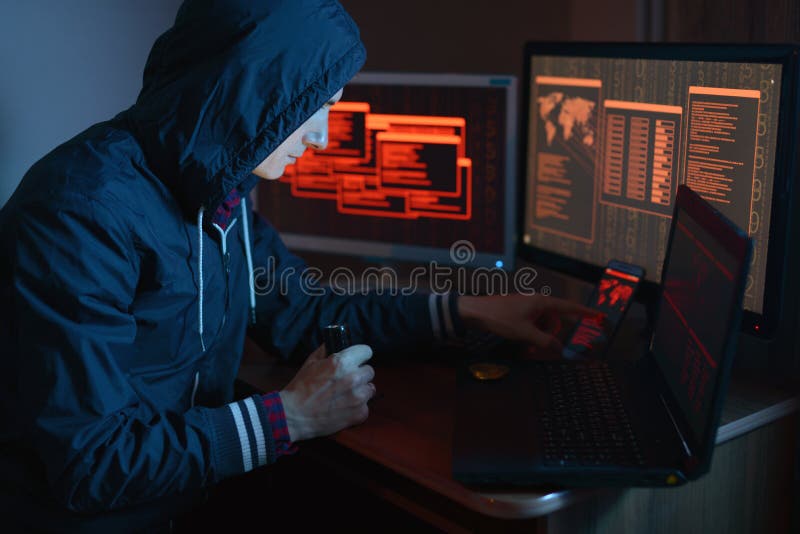 Hacker in the Hood is Pointing His Finger at the Display Indicating the ...