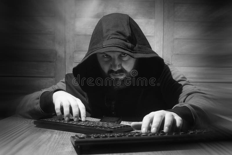 The Hacker in the Hood Sits and Works Behind the Computer Stock Image ...