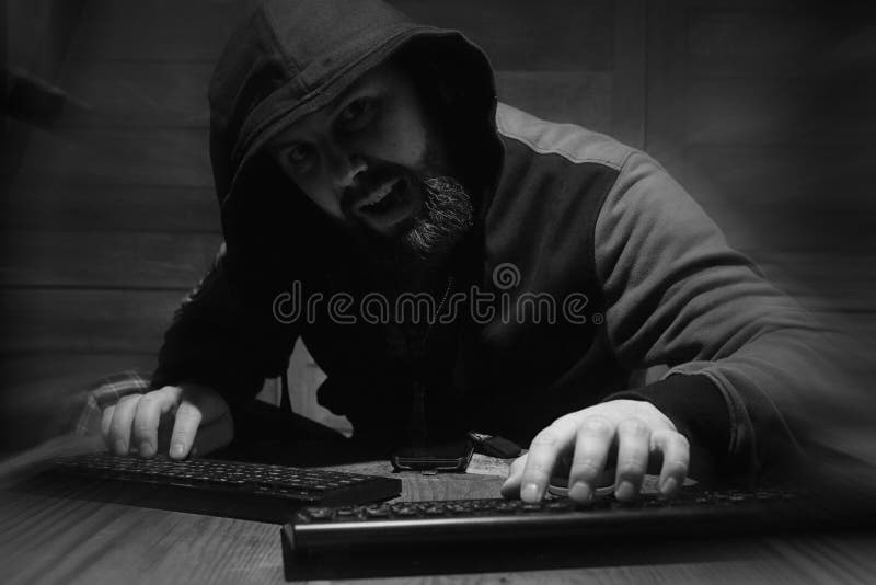 The Hacker in the Hood Sits and Works Behind the Computer Stock Image ...