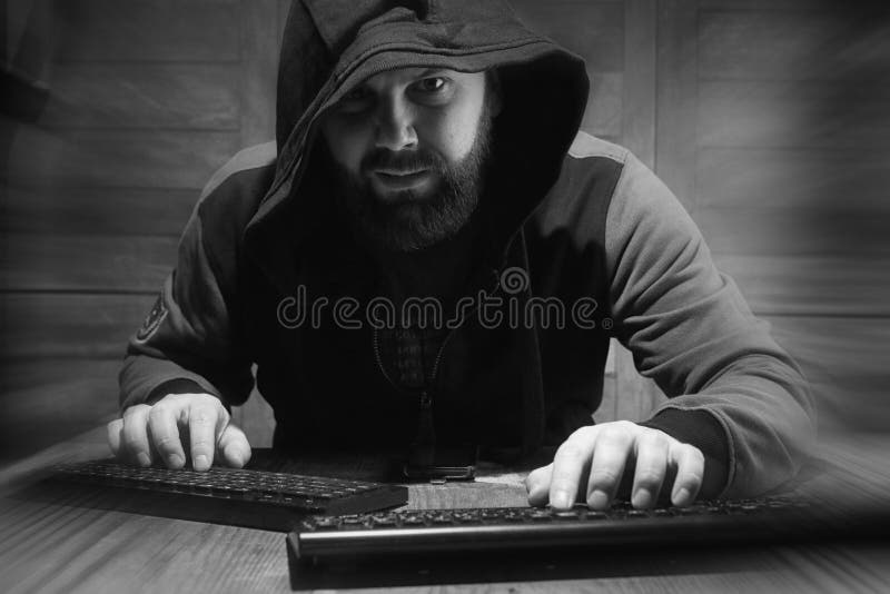 The Hacker in the Hood Sits and Works Behind the Computer Stock Image ...