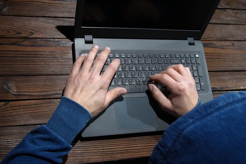 A Hacker with Laptop Sits at a Table and Abstract Binary Code. Business ...