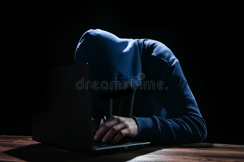 A Hacker with Laptop Sits at a Table and Abstract Binary Code. Business ...