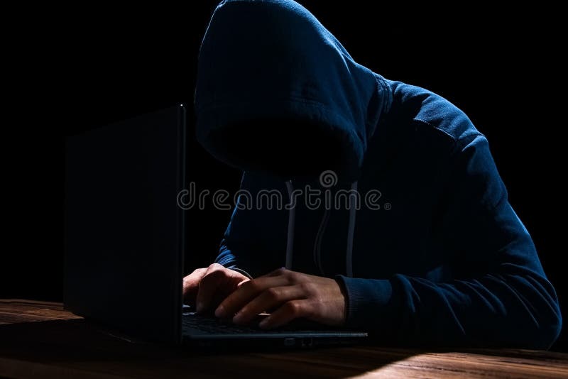 A Hacker with Laptop Sits at a Table and Abstract Binary Code. Business ...